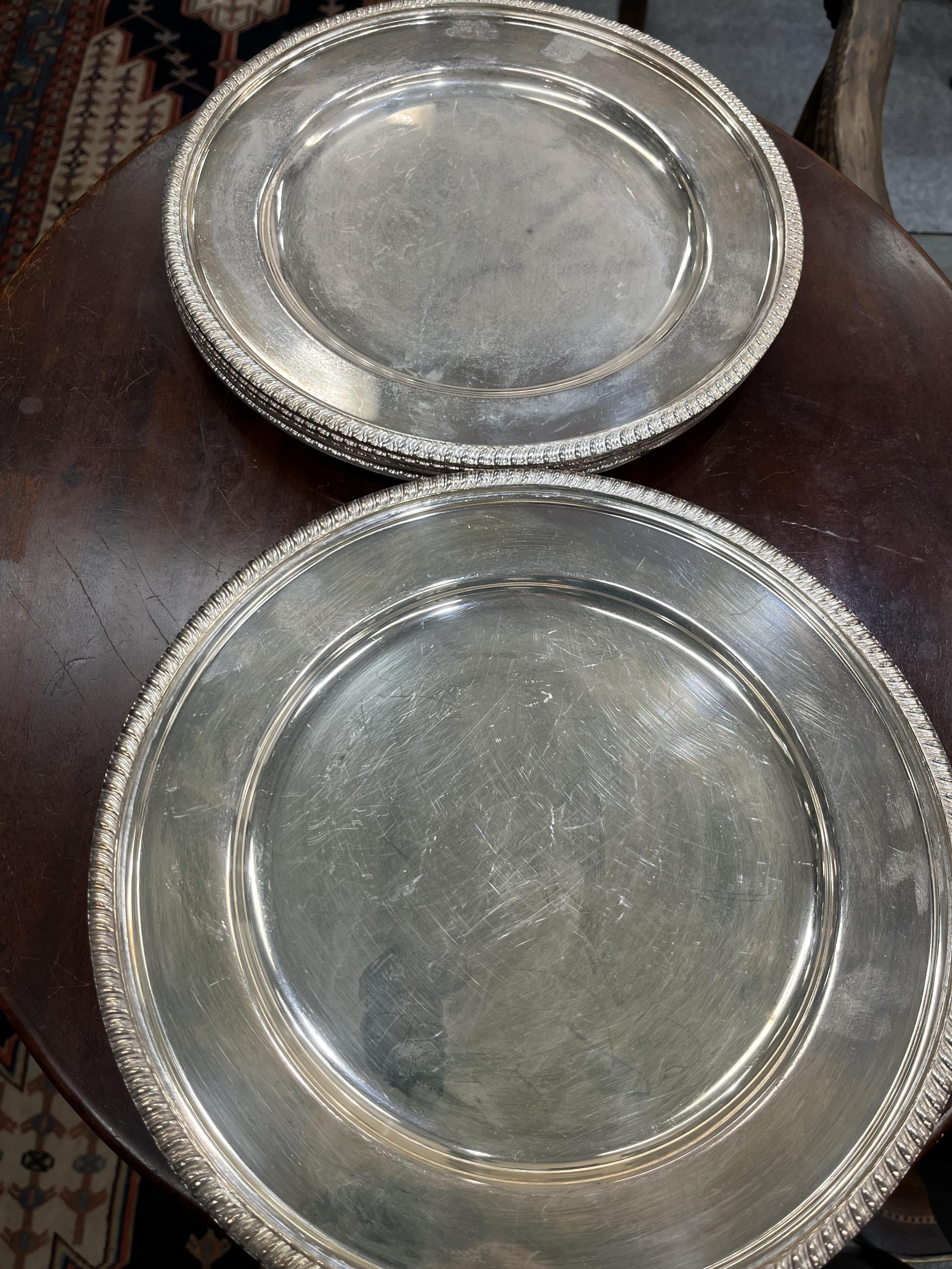 Lot 1132 - A SET OF TWELVE SILVER-PLATED DINNER PLATES,